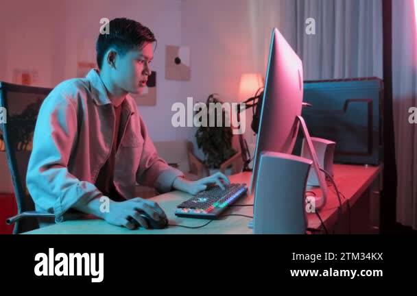 Waist up of Asian gen z gamer playing exciting online computer game in ...