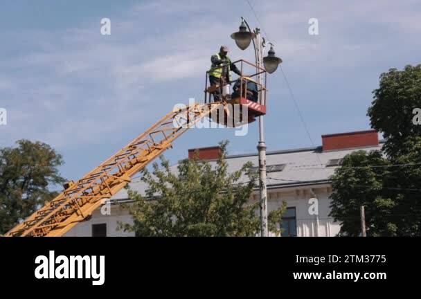 repair street lamp, lift bucket, crane lifted. Worker is fixing street ...