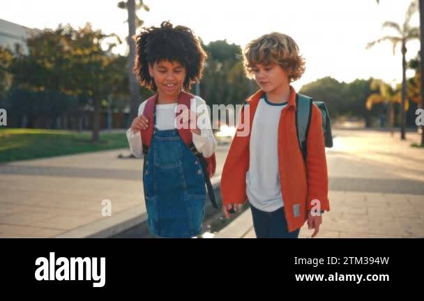 Happy smart kids with school bags rush to the lessons at school. Back ...