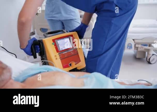 Reanimation of patient with defibrillator. Doctor using external ...