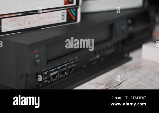 Insert VHS cassette into VCR and push play button. Black vintage ...