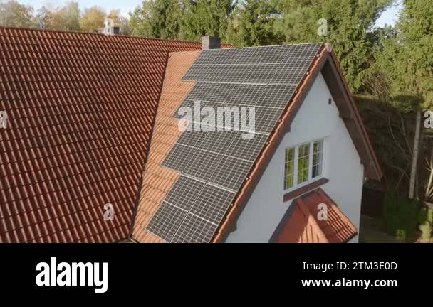 Photovoltaic solar modules are installed on the tiled roof of a private ...