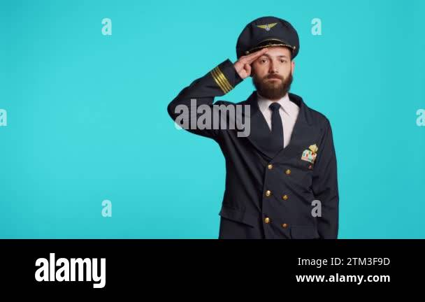 Young pilot showing military salute in studio, expressing respect for ...