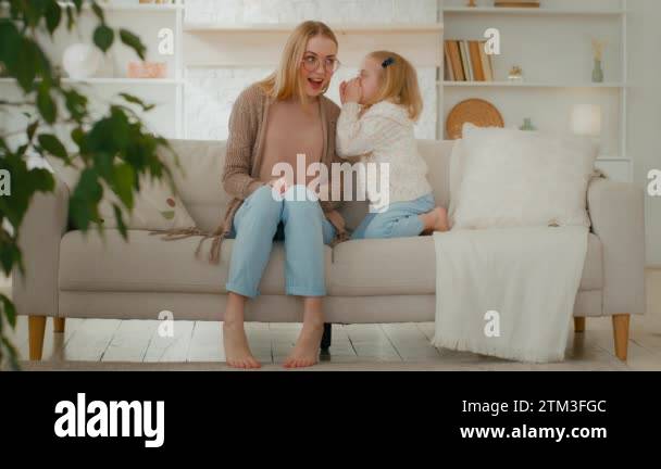 Caucasian little girl daughter child kid whisper secret gossip to mum ...