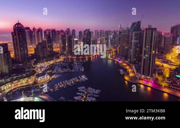 Dubai marina harbor with boats and yacht panorama from night to day transition panoramic ...