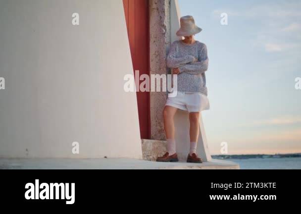 Relaxed traveler posing house at evening lake. Casual beautiful woman ...