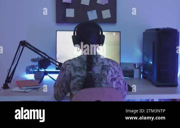 Rear view medium slowmo of gen z teenage zoomer in headphones playing ...