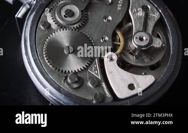 The mechanism of vintage stopwatch rotates close-up. Round clock watch ...