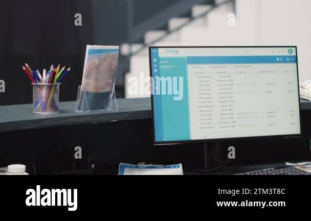 Medical appointments on computer at desk, empty reception area in ...