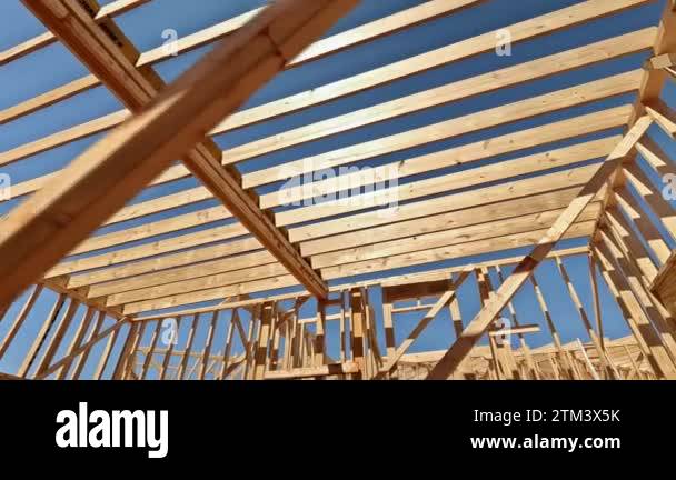 An enclosing beam supports framework of layout joists in newly constructed wooden structure ...