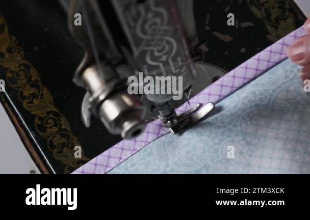 Old female hands of seamstress sew at a retro sewing machine at home in ...