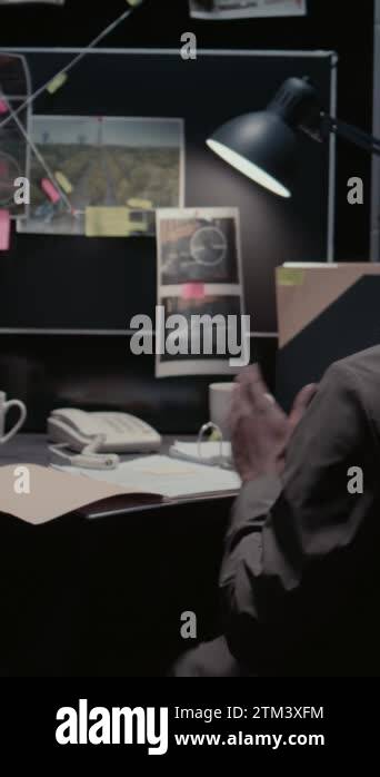 Vertical video: African american agents examining surveillance photos ...
