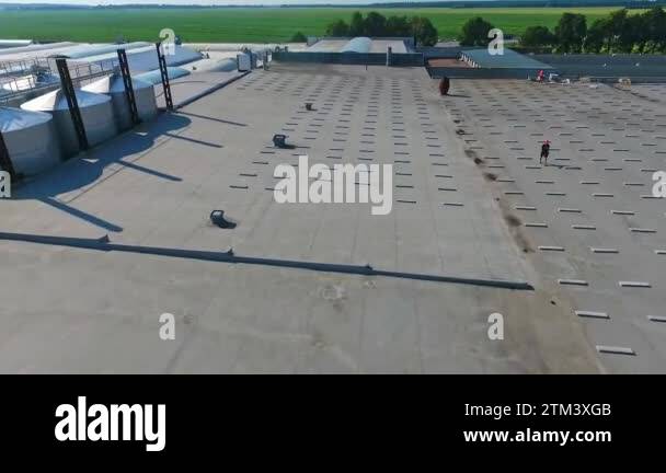 Building the solar farm on flat roof. Flying over the construction site ...