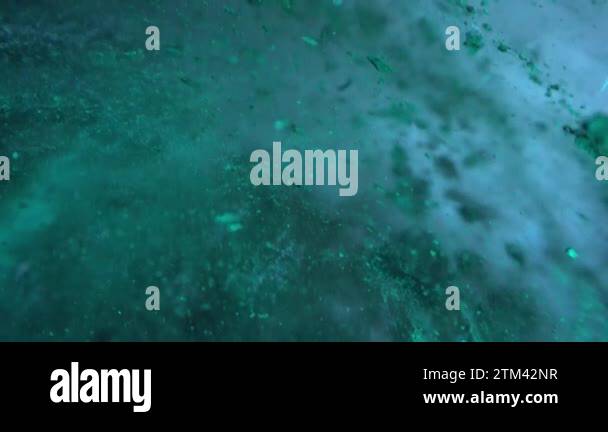 Turquoise pure color of ice inside the ice cave. Stones and icicles are ...