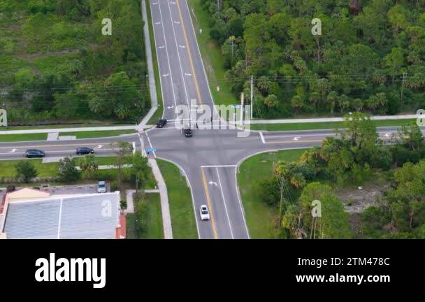 Suburban road with driving vehicles at intersection with traffic lights ...