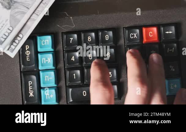 Top view counting on an old vintage calculator surrounded by dollar ...
