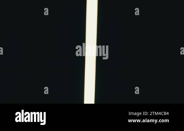 Neon LED sword moves from side to side on black background. The bright ...