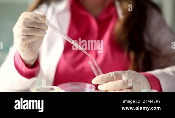 Laboratory assistant drops yellow liquid into test tube. Oil quality ...