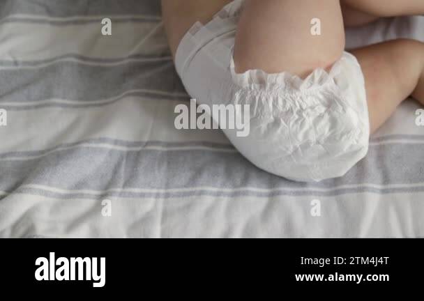 diaper change cute little baby boy lies on bed mother woman putting on ...