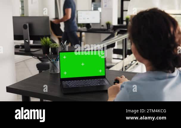 Employee uses greenscreen layout on laptop, working on business ...