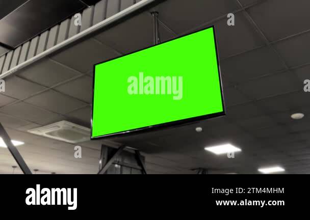 Chromakey green screen on a flat-screen TV, ceiling-mounted in a gym ...