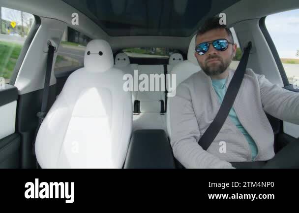 Mature male driver inside Tesla Model Y car using self drive autopilot ...