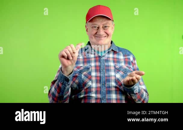 Senior man looking at camera, snapping his fingers and extends his palm ...