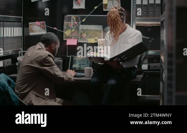 Two police officers looking at detective evidence map, investigators ...