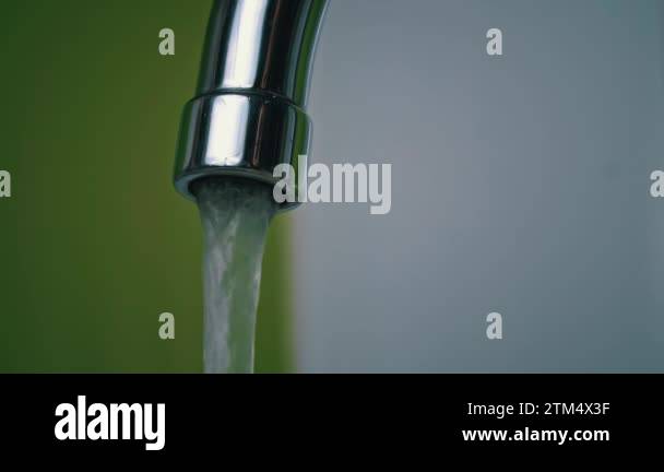 Close-up of water flowing from a kitchen faucet. drinking water from ...