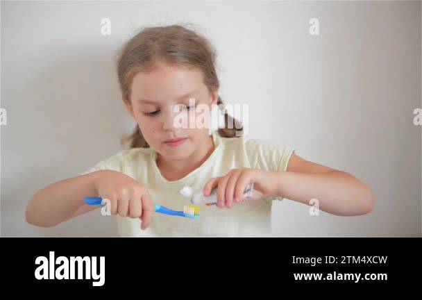 Little girl in bathroom putting a toothpaste on toothbrush Stock Video ...