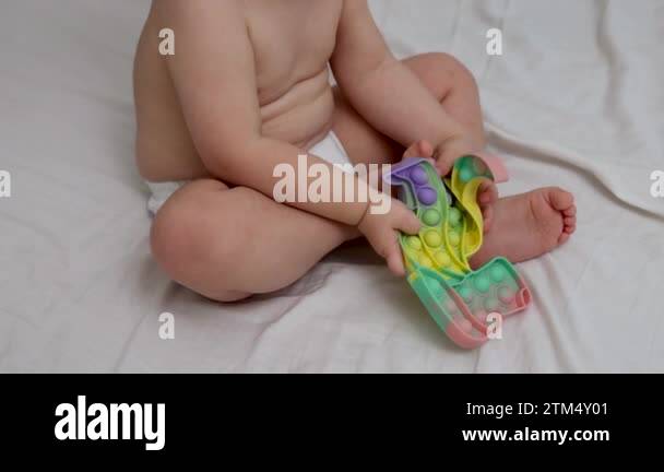 crying baby lying on bed rubbing eyes with hands.angry sleepy upset ...