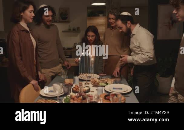 Full shot of teenage Jewish girl in glasses standing at dinner table ...