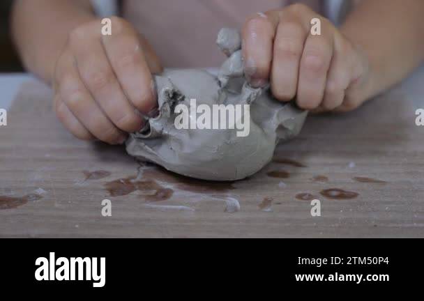 A child shapes clay during a pottery masterclass. Close-up of childrens ...