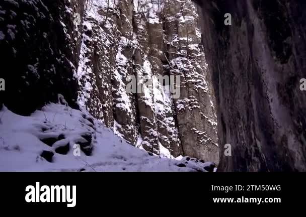 Gorge and giant rocky formations covered with white snow in highland ...