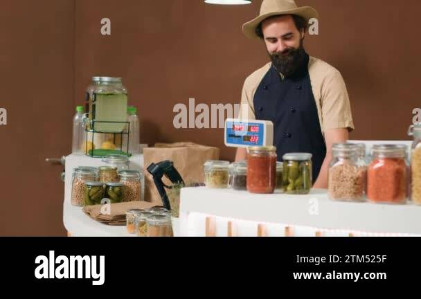 Local farmer vendor weighting produce at cash register counter, using ...