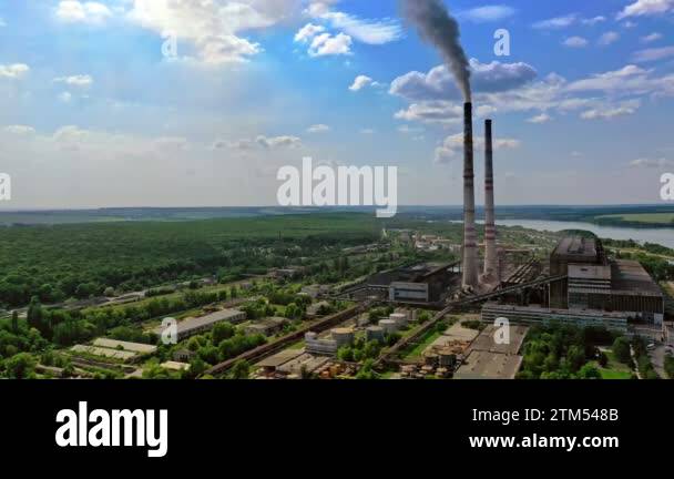 Industrial territory among nature. Factory with pipes against blue sky ...