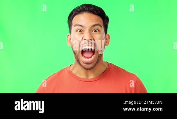 Scream, face and man in a studio with green screen with a yelling or ...
