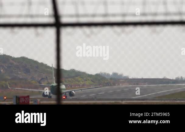 Rear view of a commercial airplane accelerating and taking off. View of ...