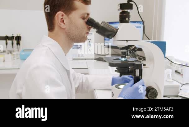 Male doctor using microscope in laboratory. Side view of man in lab ...