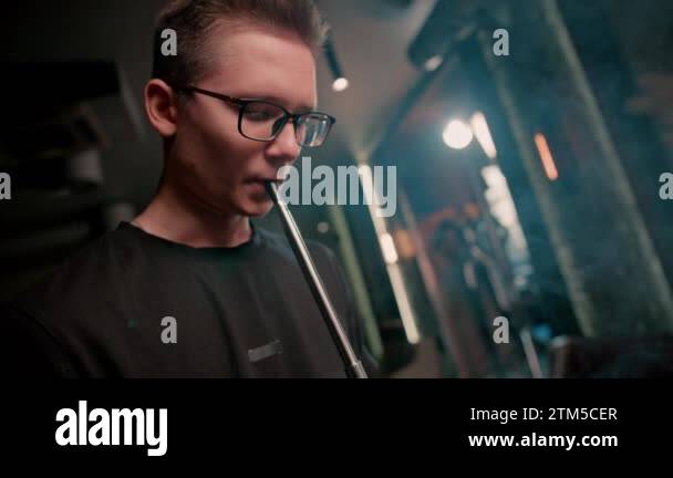 A hookah man in glasses smokes a traditional hookah pipe A man exhales ...