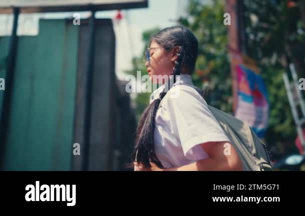 a female student walks into the school gate with a sad face in the ...