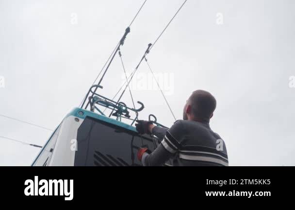 Bottom view of professional driver stands at back side of trolleybus ...