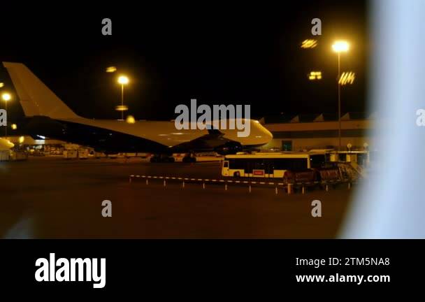 Night view of an airport terminal from a taking off airplane window ...
