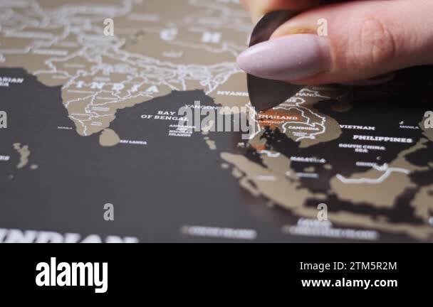 Woman hand erases visited country of Thailand on the travel map ...