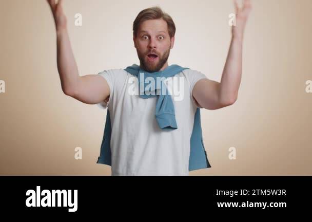 Excited amazed caucasian man touching head and showing explosion ...