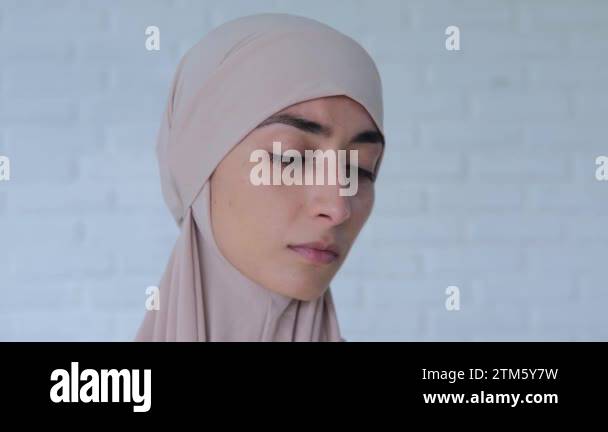 Muslim woman in hijab looks up sadly at camera. Beautiful facial features, steadfast gaze and ...