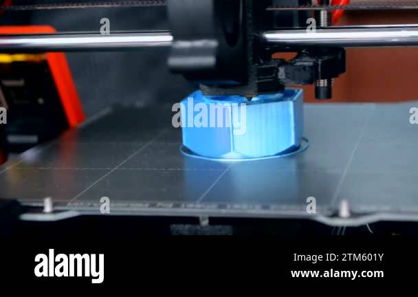3D printer. 3d printer printing close-up. Molten plastic flowing out of extruder and forming ...