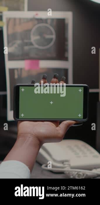 Vertical video: Police officer using greenscreen in evidence room ...