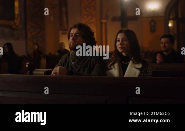 Husband and wife attentively listen to the preaching of the priest. A ...