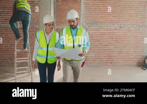 Team architect or engineer man and woman walking and looking blueprint ...